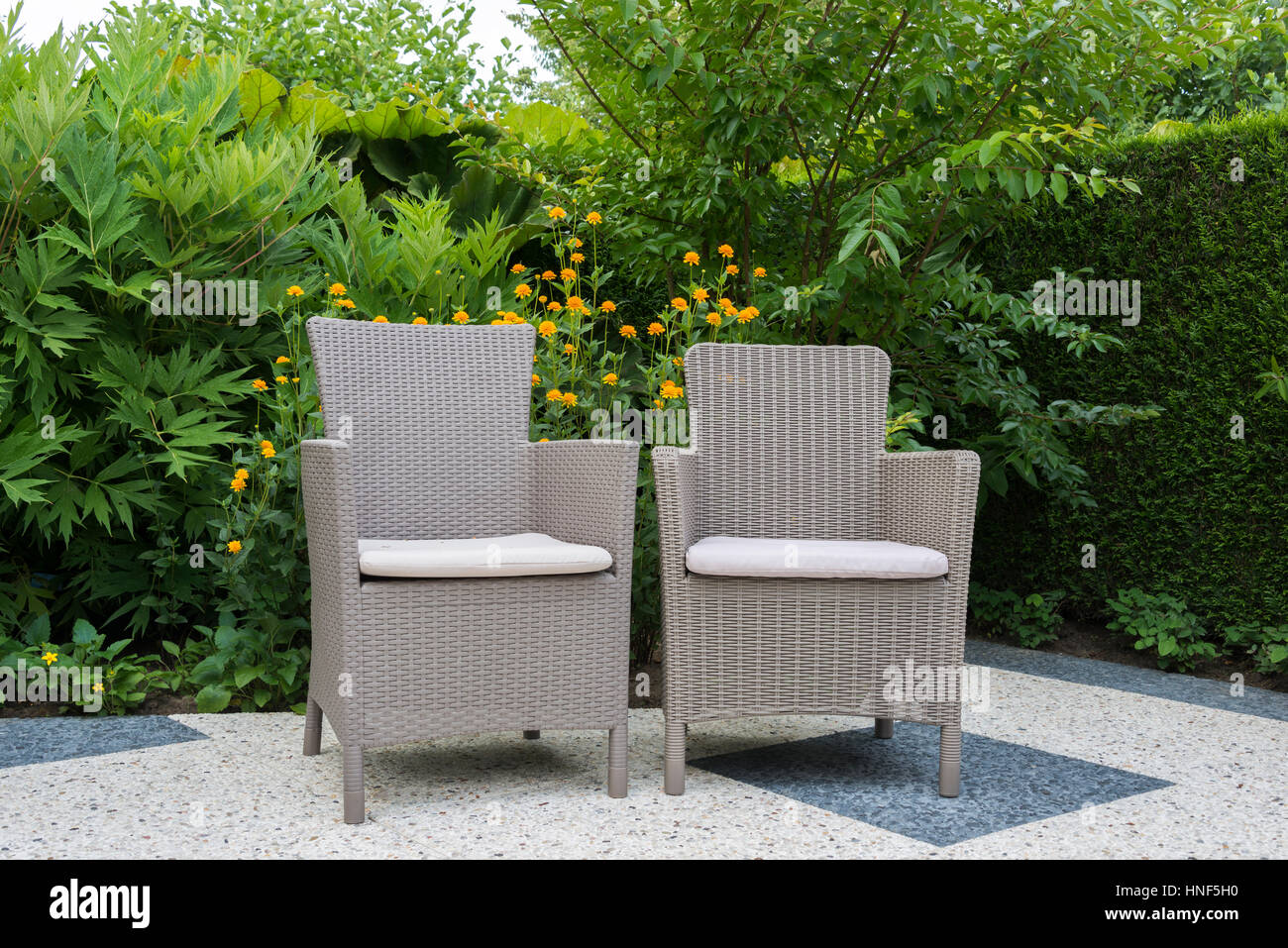terrace with rattan relax chairs in garden with flowers as background ...