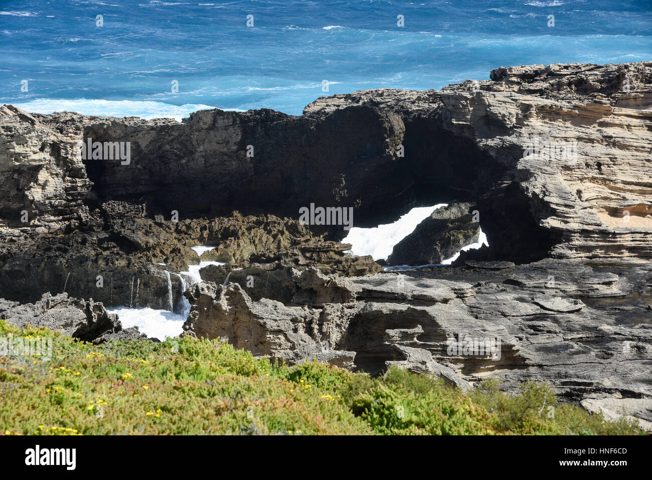 Natural arched limestone formation with turquoise Indian Ocean waters ...