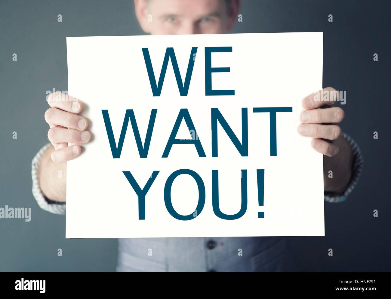 man holding a sign with the words We Want You Stock Photo - Alamy