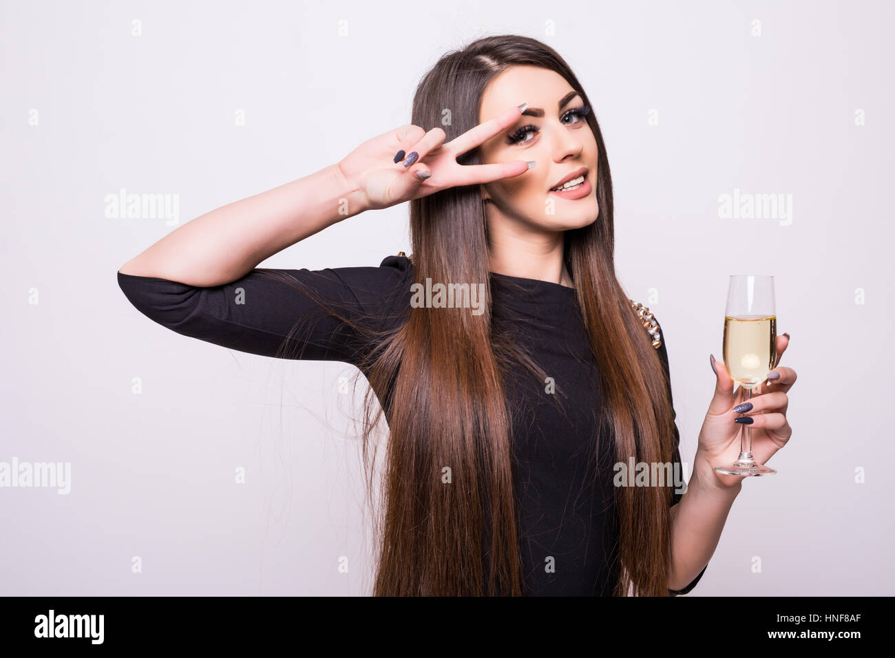 Young girl in black dress drink champagne on white background Stock ...