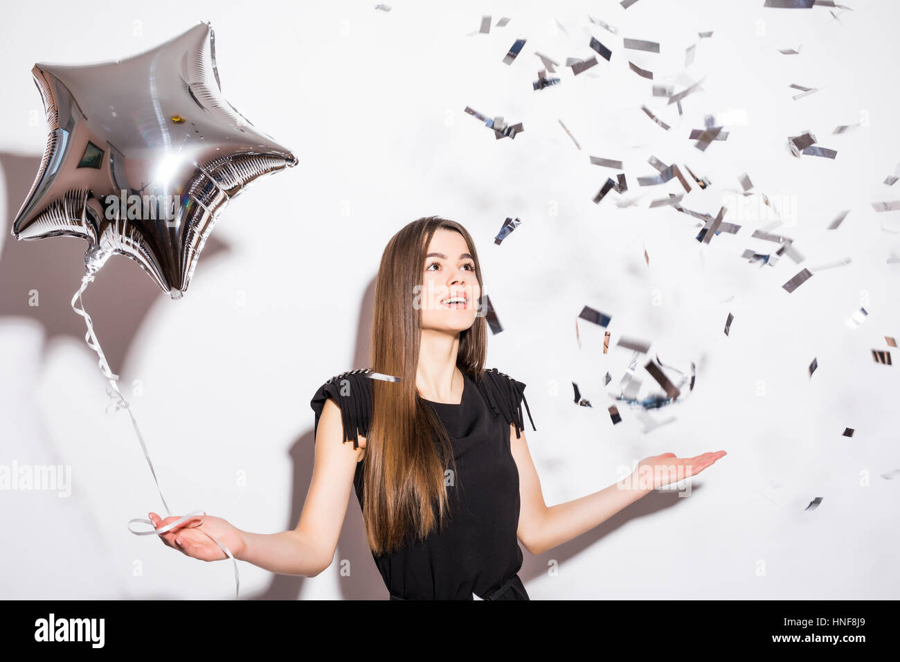 Beauty woman holding star balloon with fly confetti over white ...
