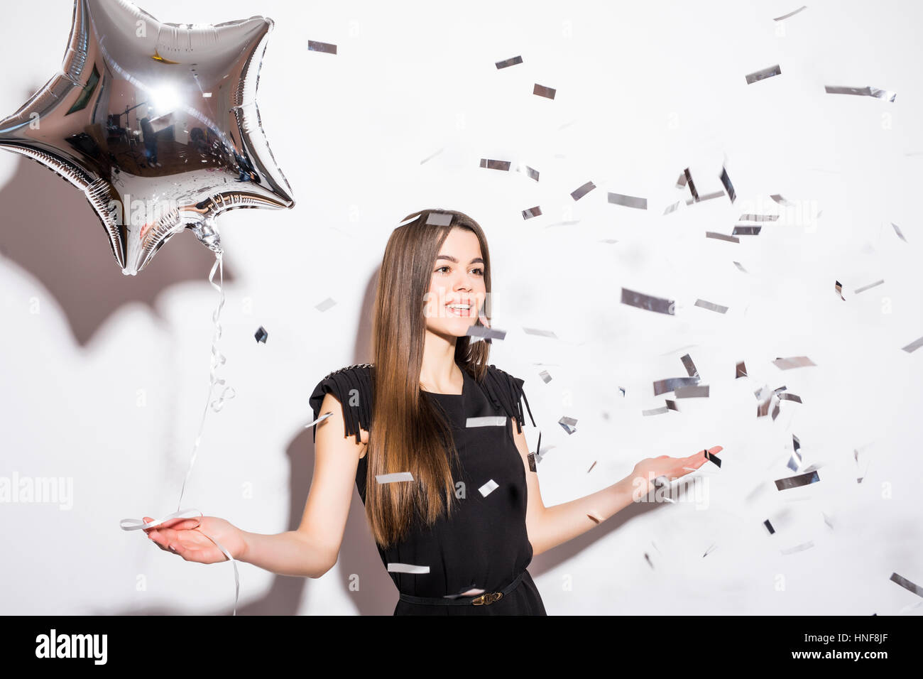 Beauty woman holding star balloon with fly confetti over white ...