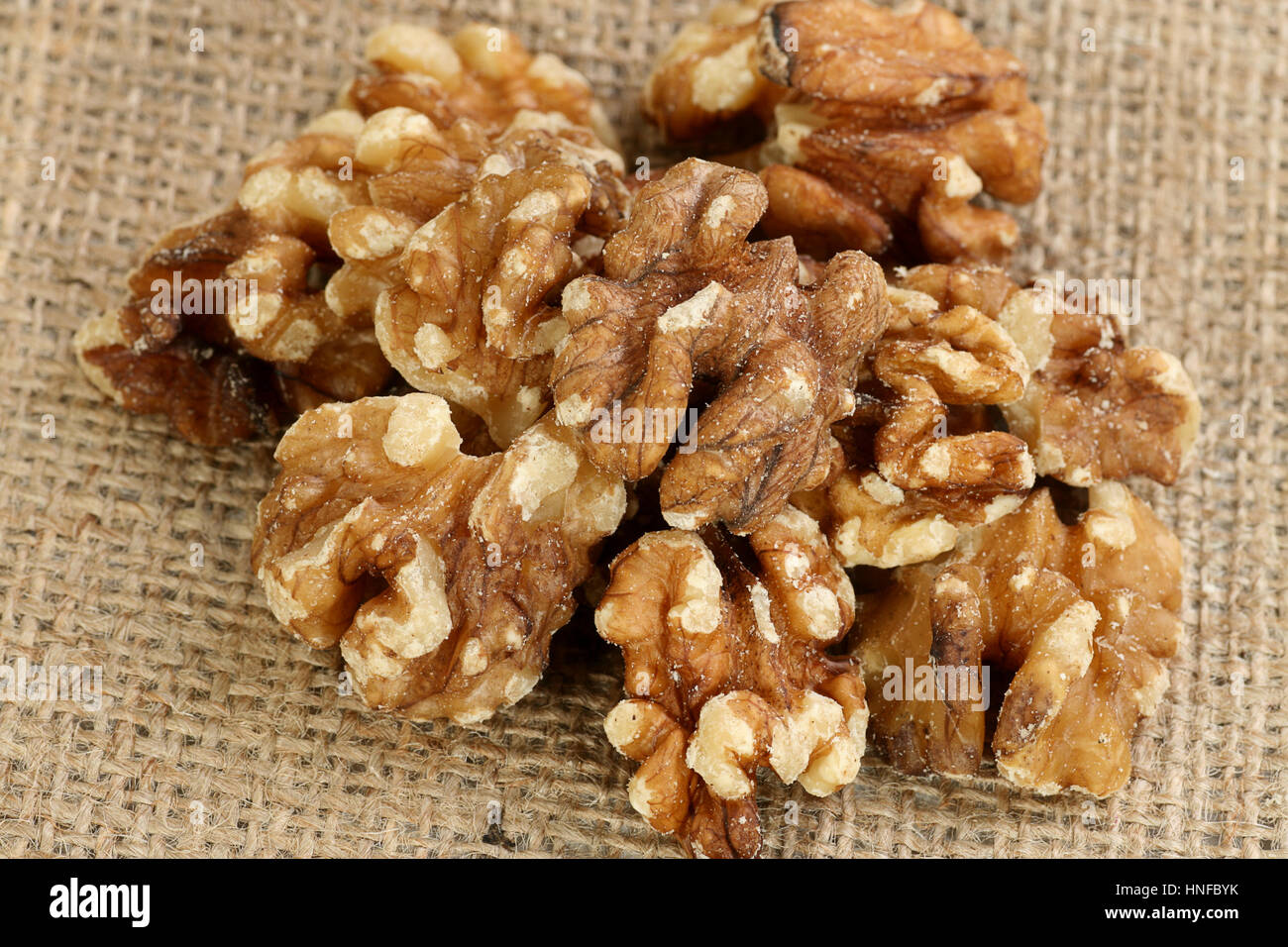 pile of shelled walnut halves on a hessian background Stock Photo - Alamy
