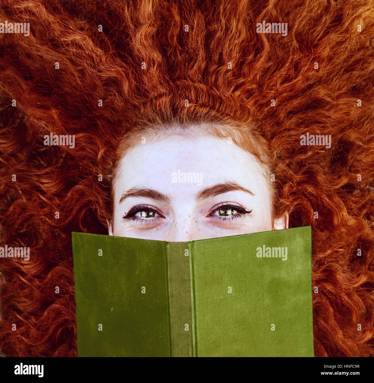 Young redhead woman reading a book Stock Photo - Alamy
