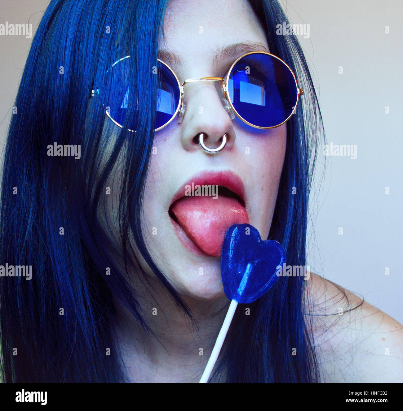 Portrait of a young woman with blue hair and a blue lollipop Stock ...