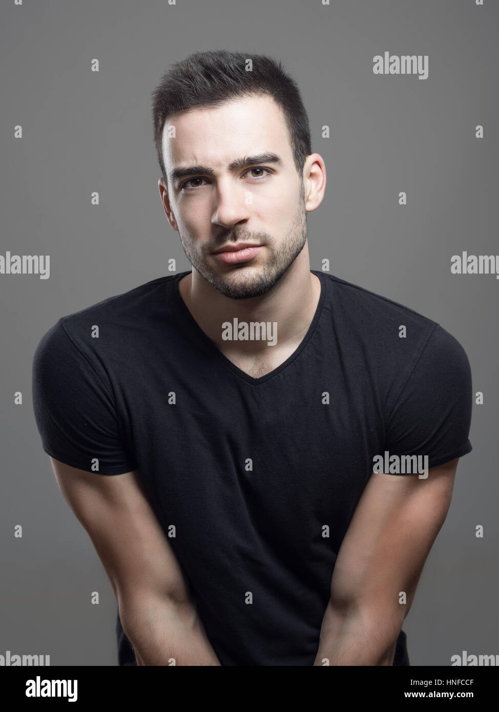 Moody portrait of fit muscular serious man wearing blank black t-shirt ...