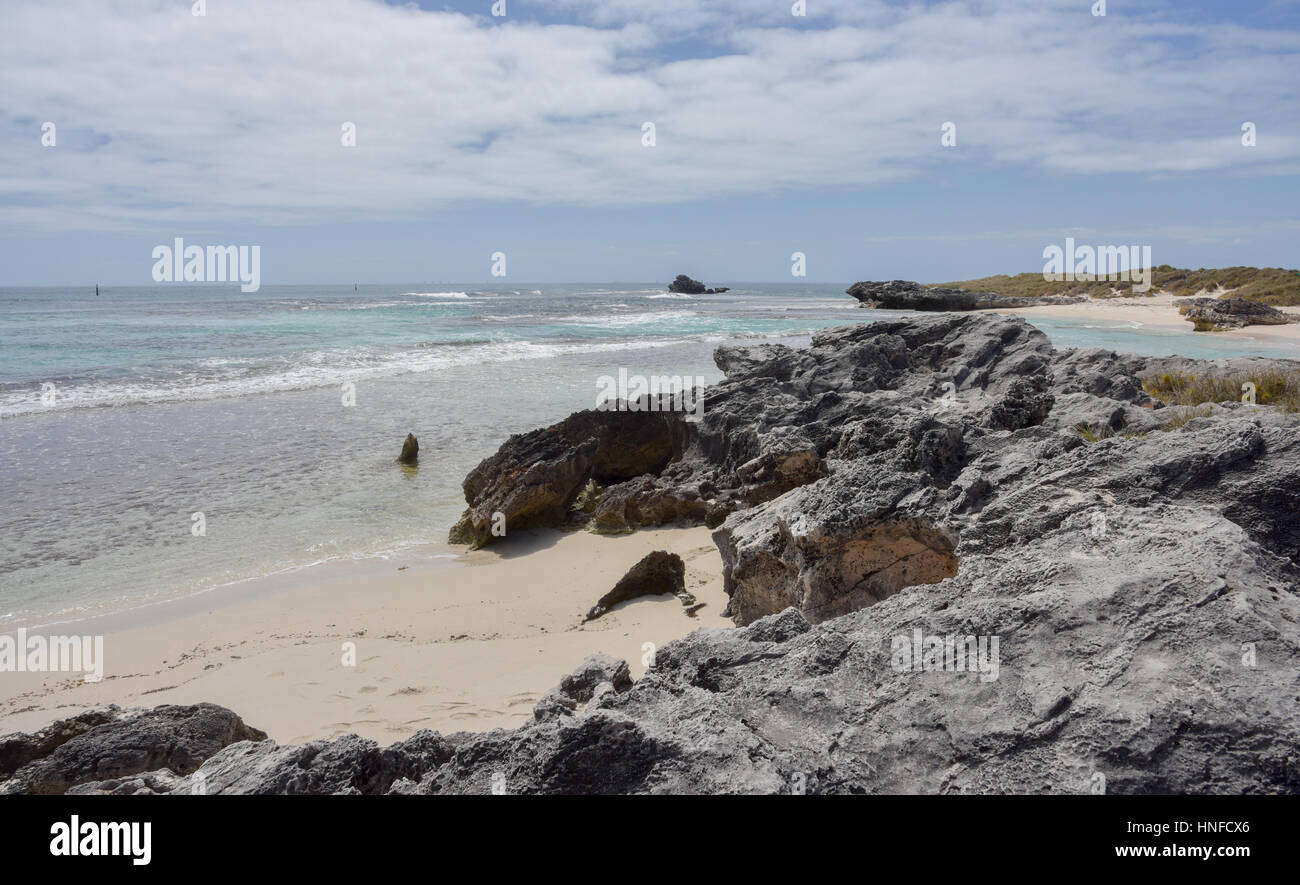 Rugged limestone rock formations on Indian Ocean beach under a cloudy ...