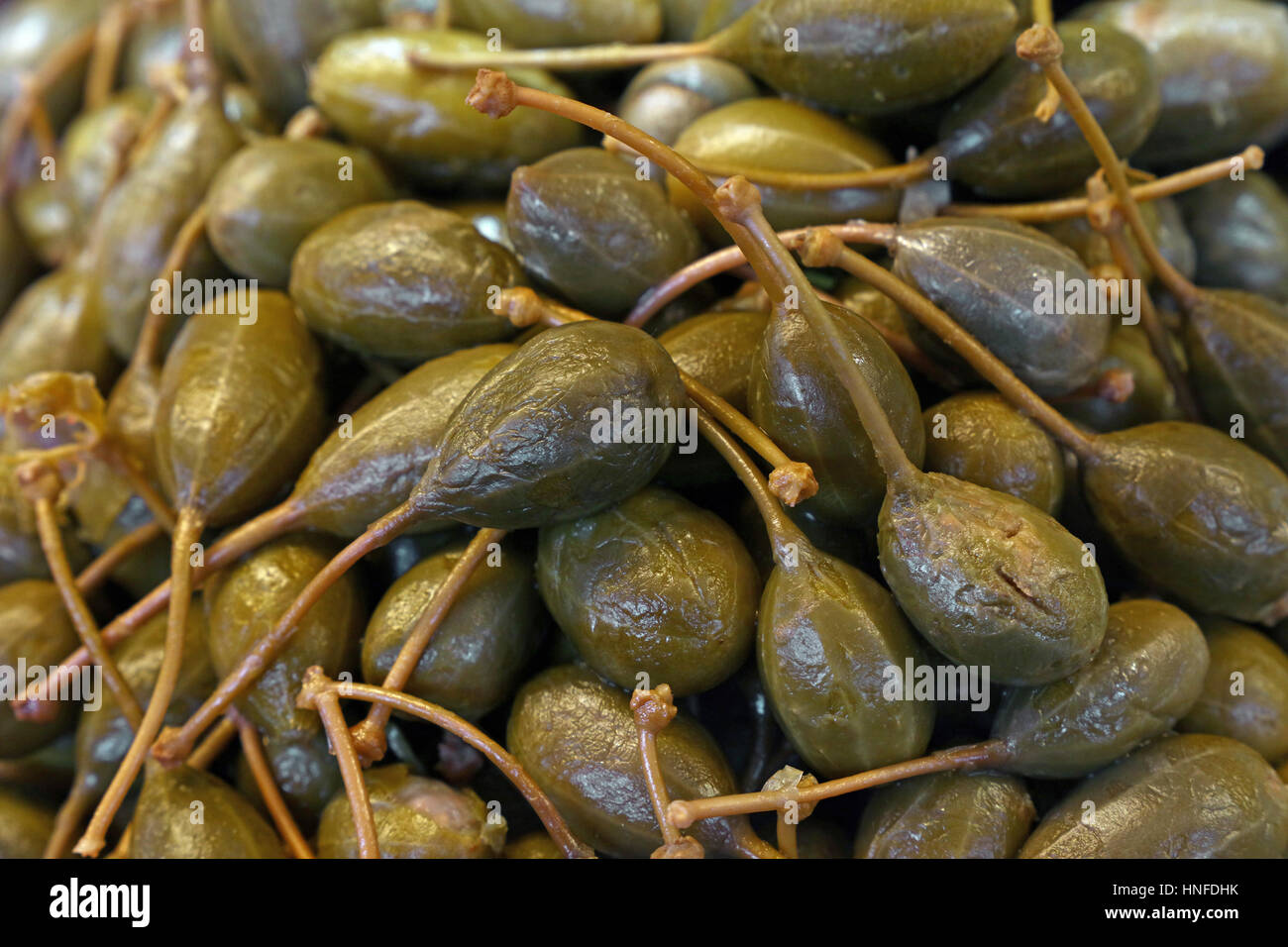 Green pickled big capers (fruits, berries, caperberries) close up ...
