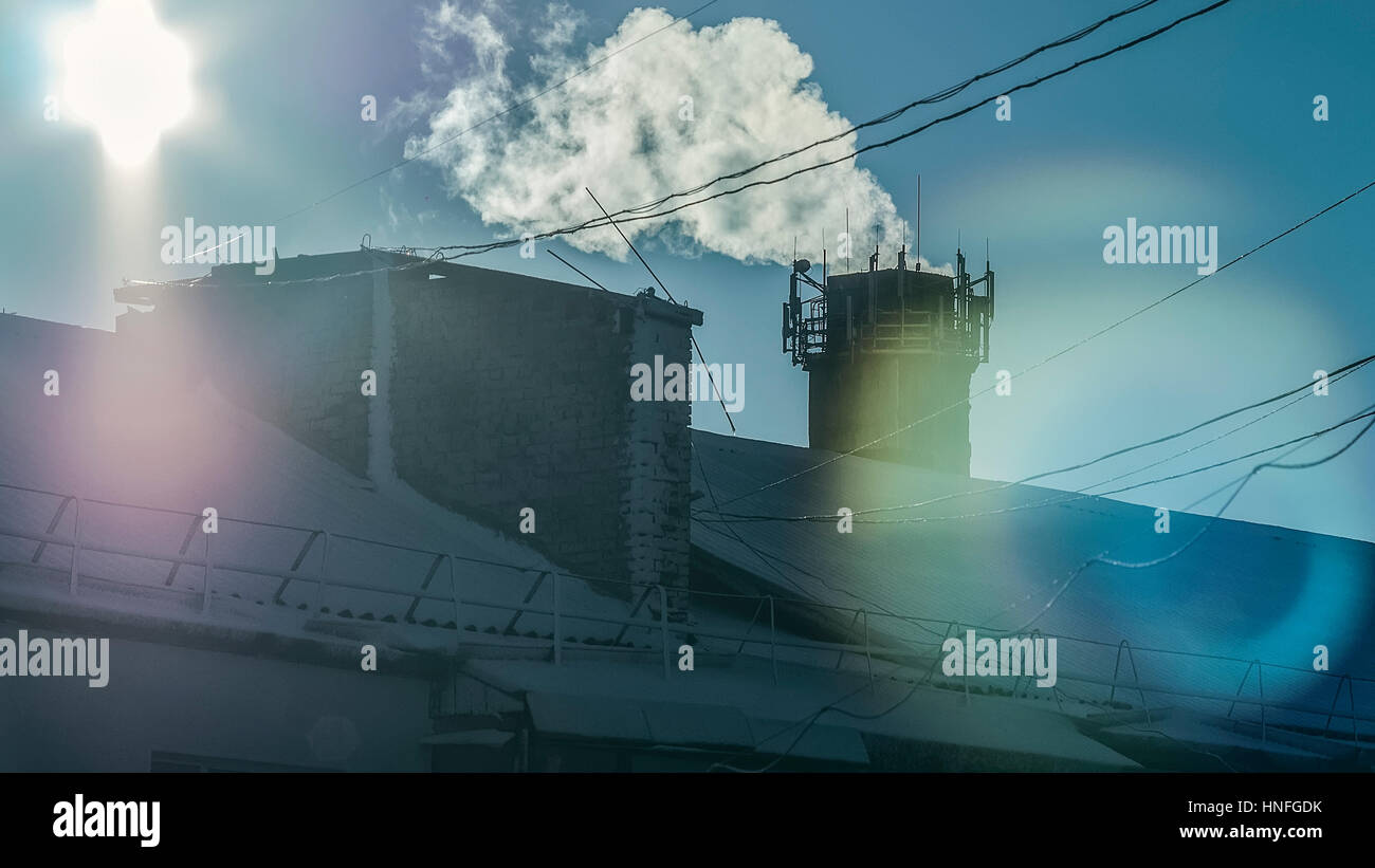 The roof of the house and a smoking pipe factory in the early morning ...