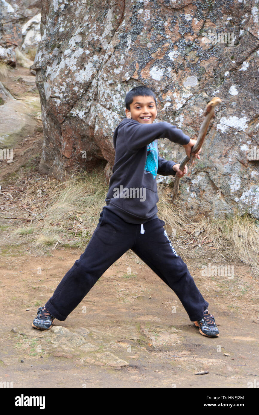 Boy playing with a stick Stock Photo - Alamy