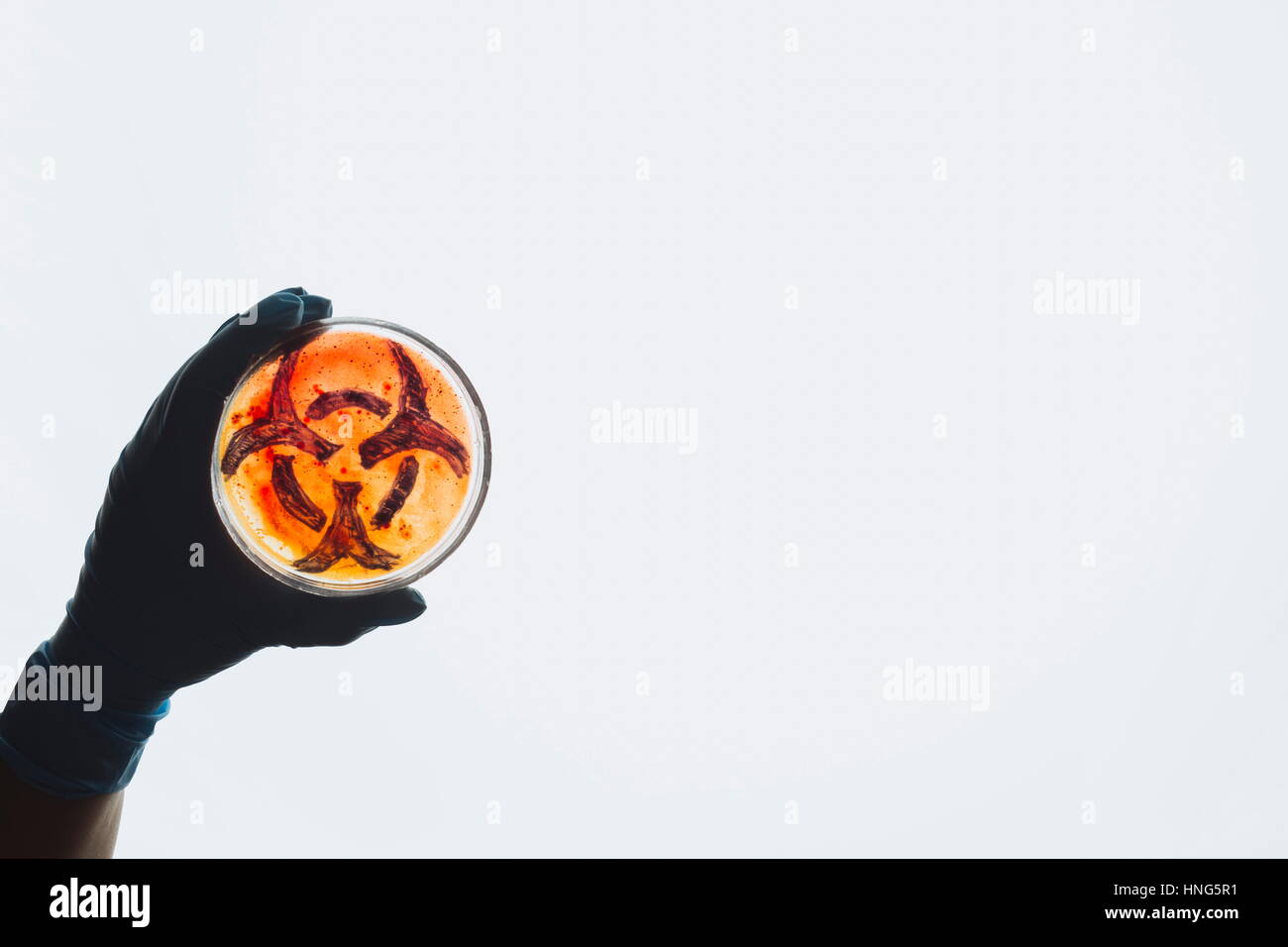 Hands hold Petri dish with biohazard symbol sign. Contaminated water ...