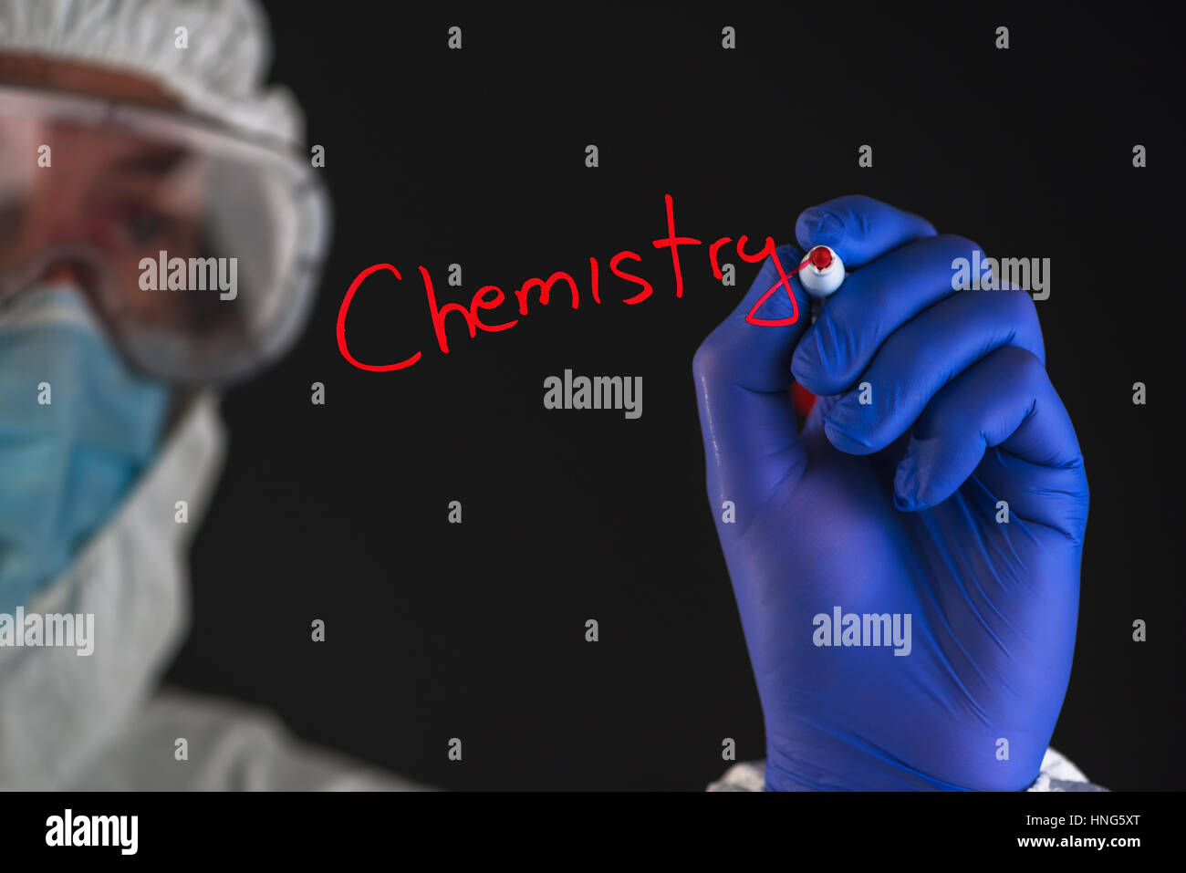 Chemical scientist writing word chemistry with red marker felt tip pen ...