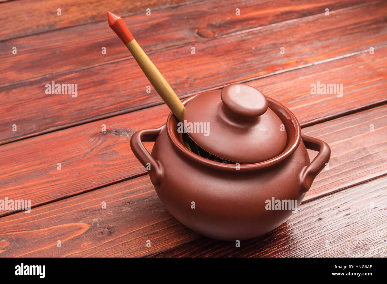 Ceramic pot with porridge on wooden background Stock Photo - Alamy