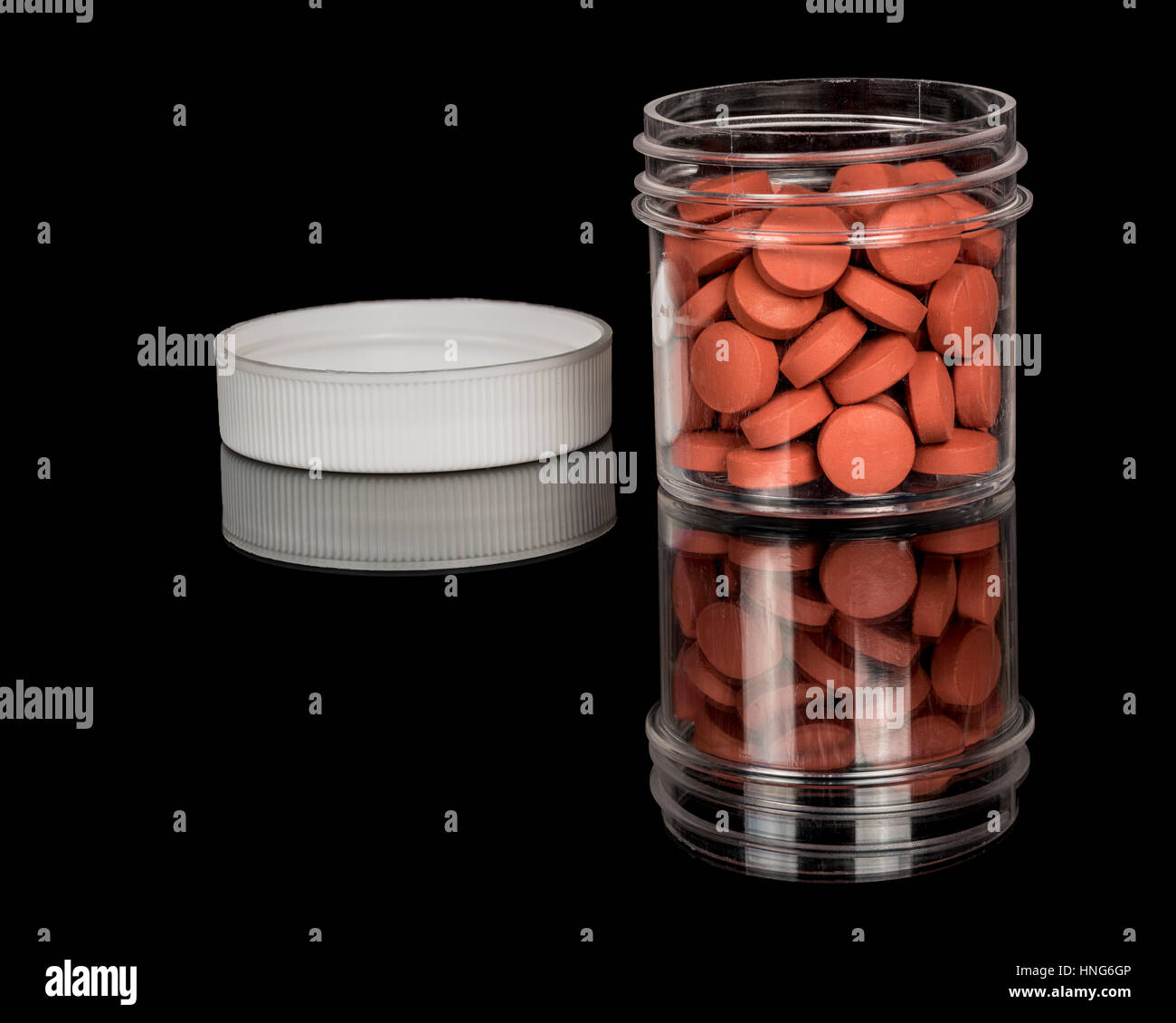 Many tan colored pills in a small container Stock Photo - Alamy