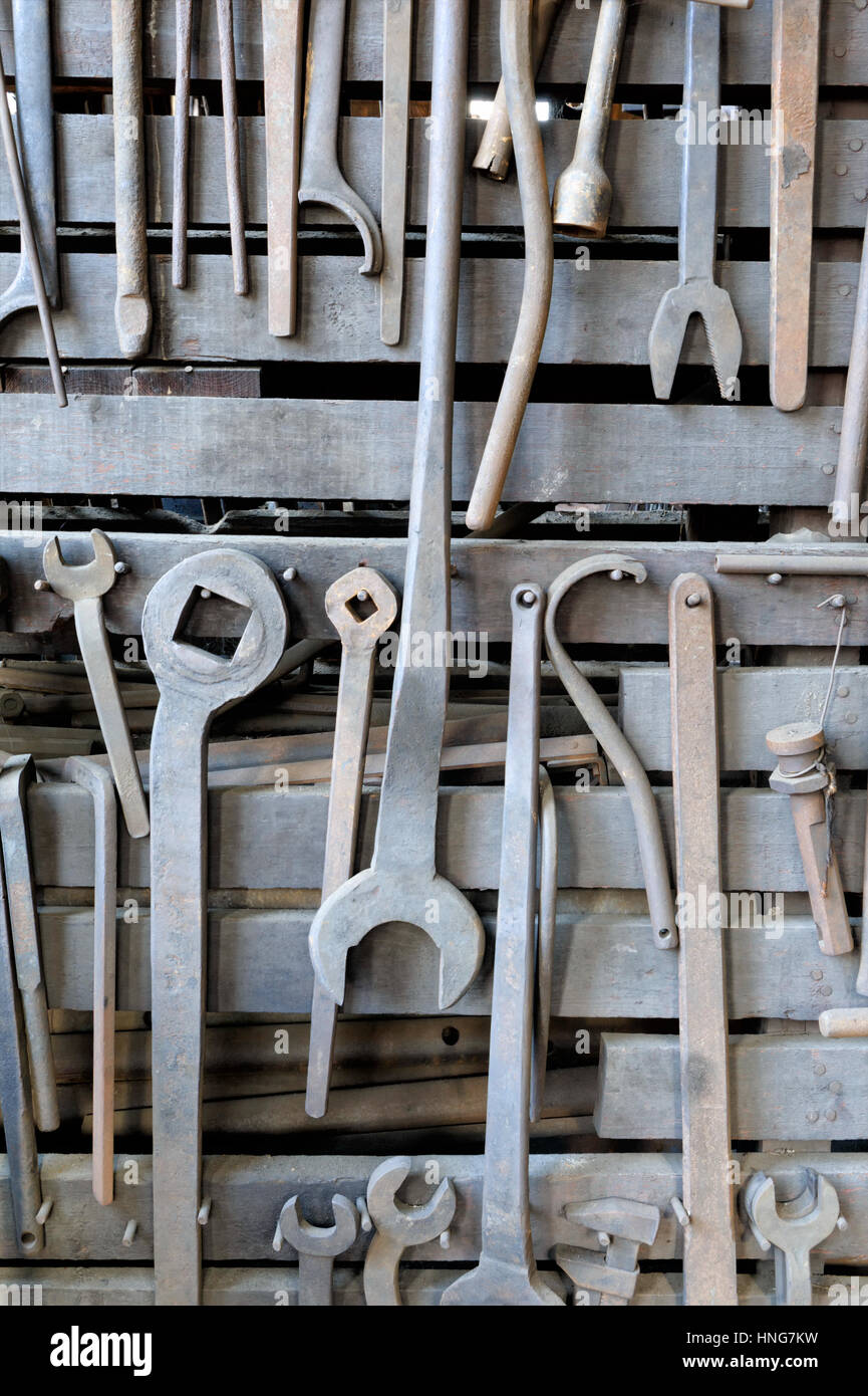 Close-up of grey tools: rows of wrenches and spanners, hanging in an ...