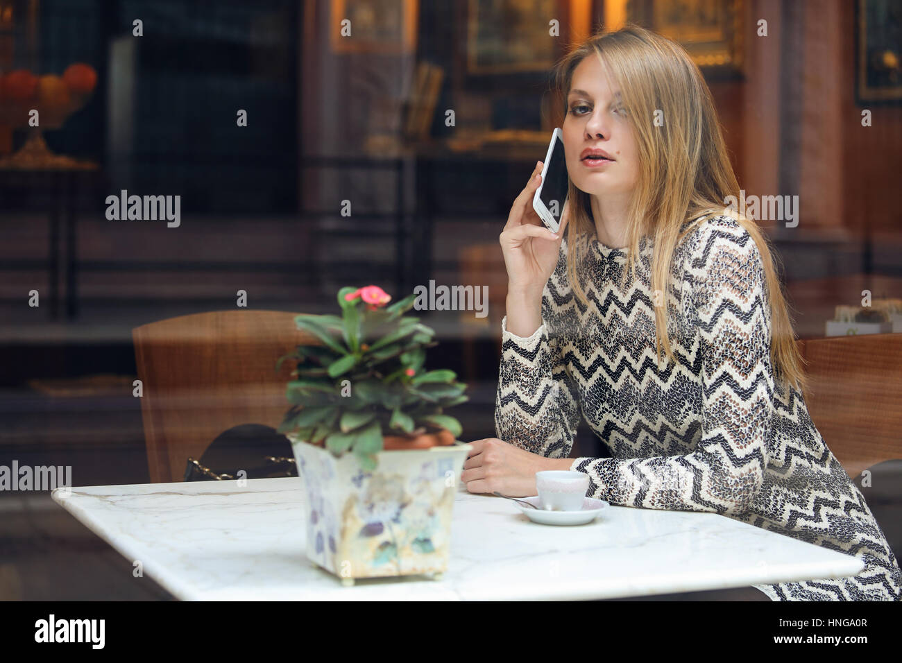 Beautiful woman calling with her smartphone. City cafe Stock Photo - Alamy