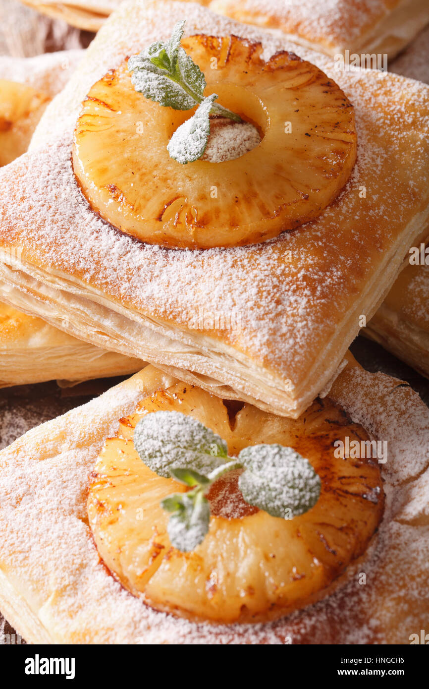 Delicious puff pastry pie with pineapple macro on the table. vertical ...