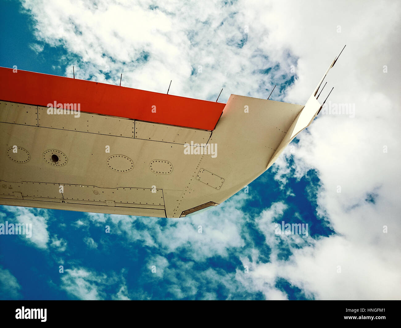Airplane wing on blue sky from below as background Stock Photo - Alamy