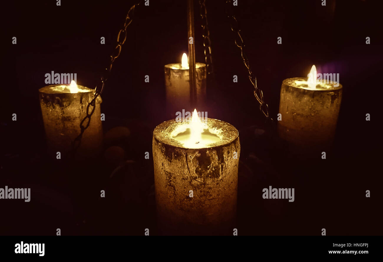 Magic candle light on chains at black Stock Photo - Alamy