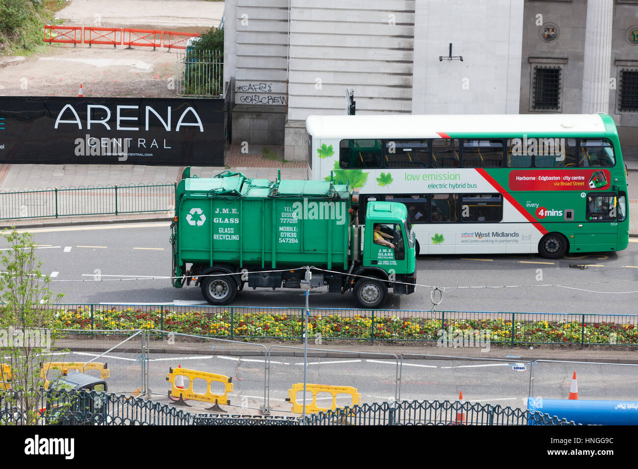A glass recycling truck alongside an electric hybrid bus. Emphasizing a ...