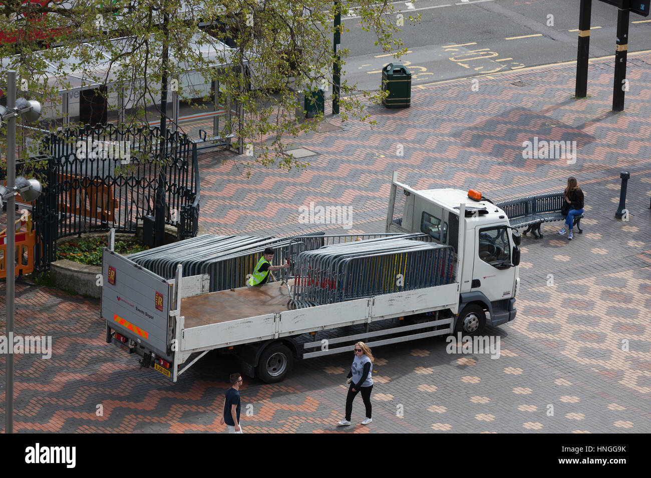 Workers loading metal barriers on the back of a flat-bed truck in ...