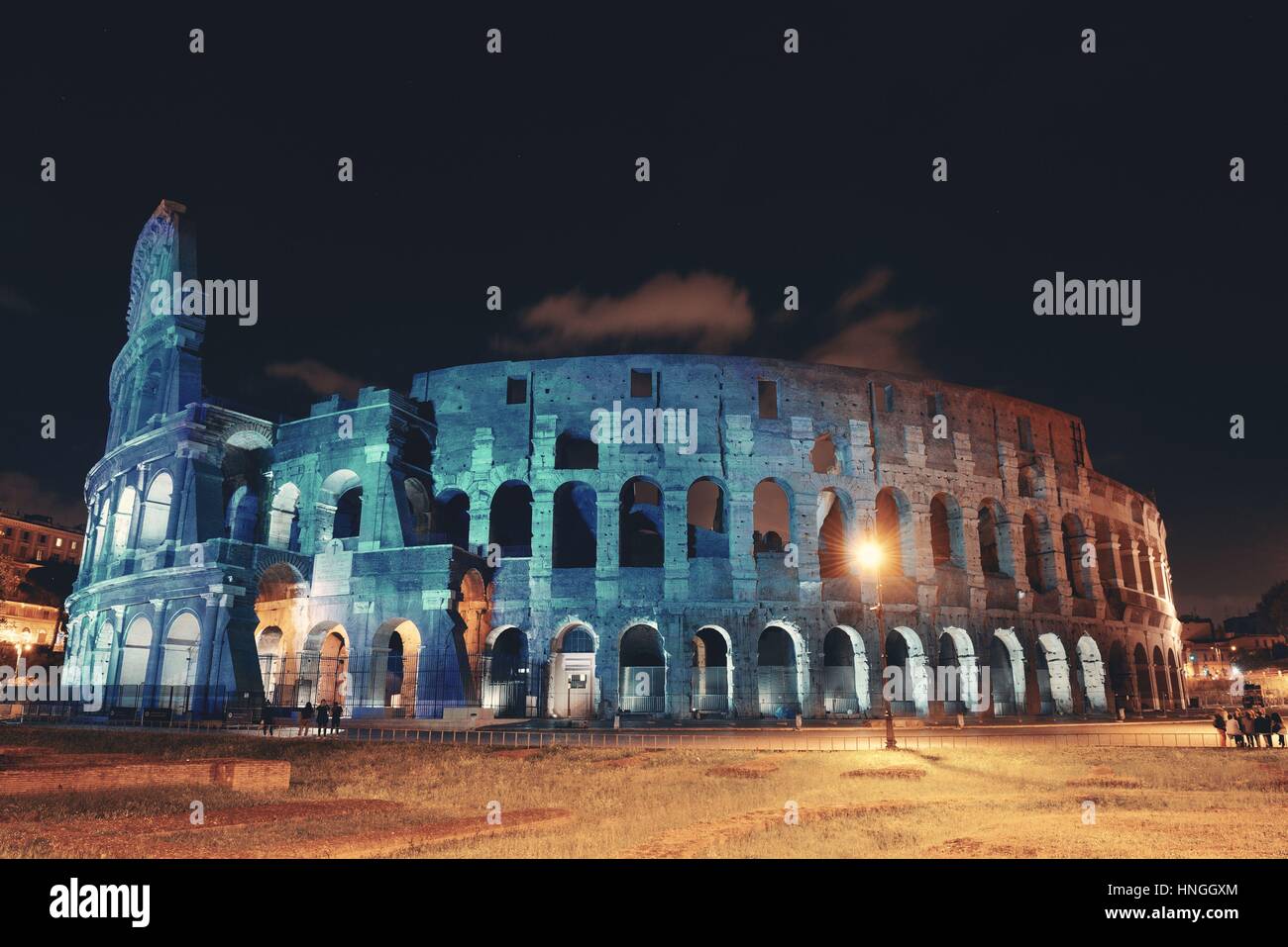 Colosseum at night with tourists and colorful lights, the world known ...