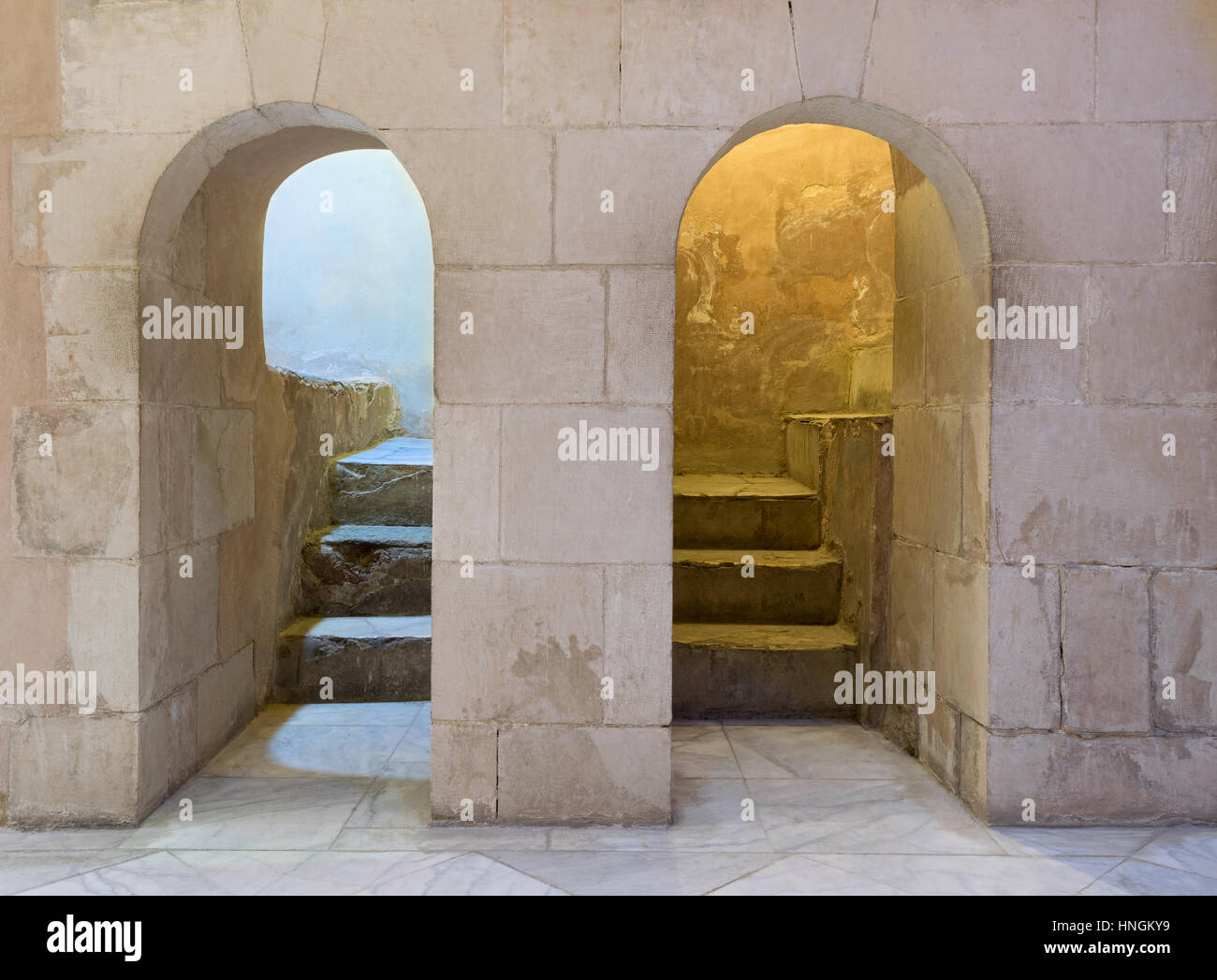 Two adjacent aged narrow dark vaulted passages and stone bricks wall ...