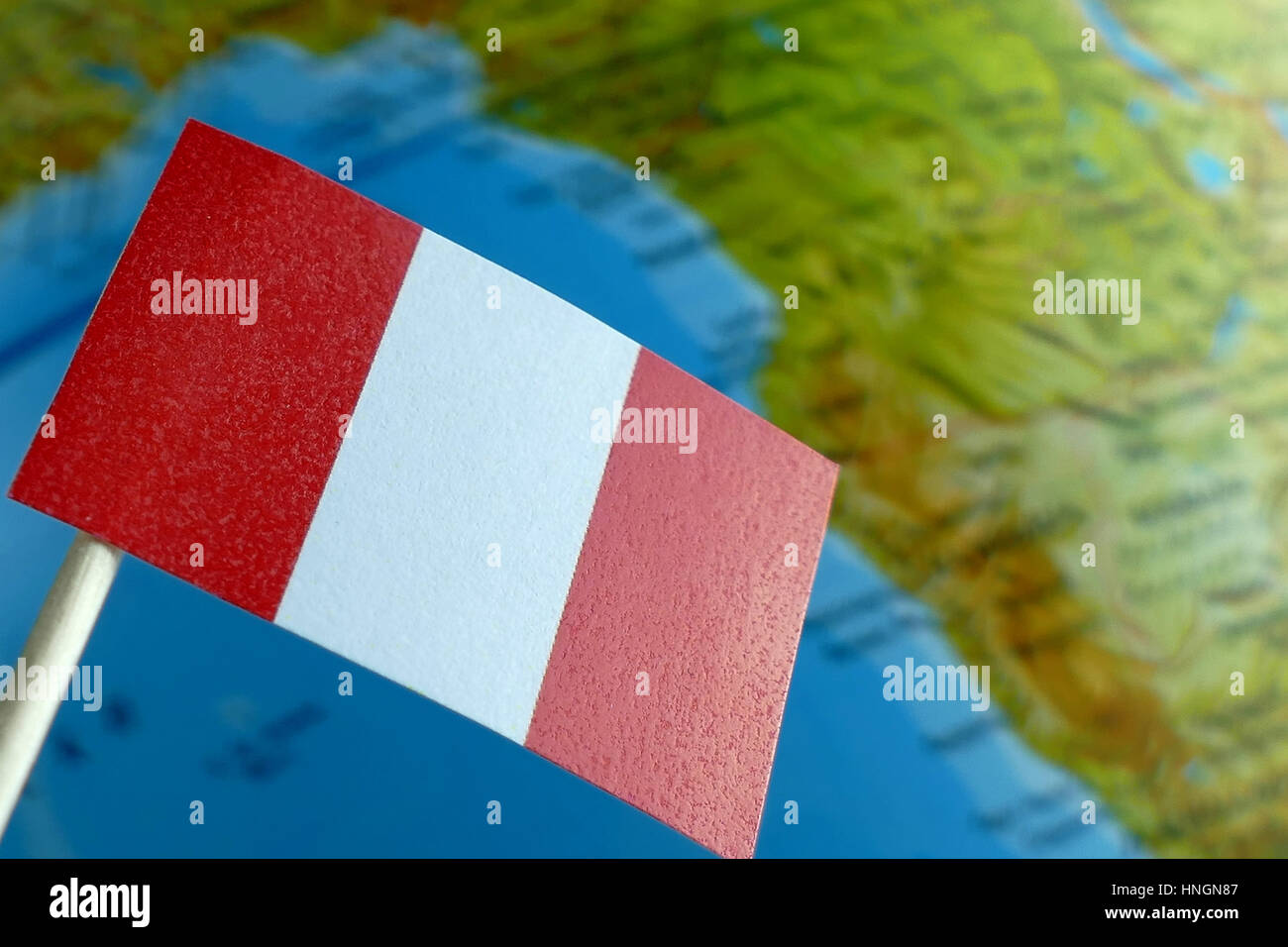 Peru flag with a globe map as a background macro Stock Photo - Alamy