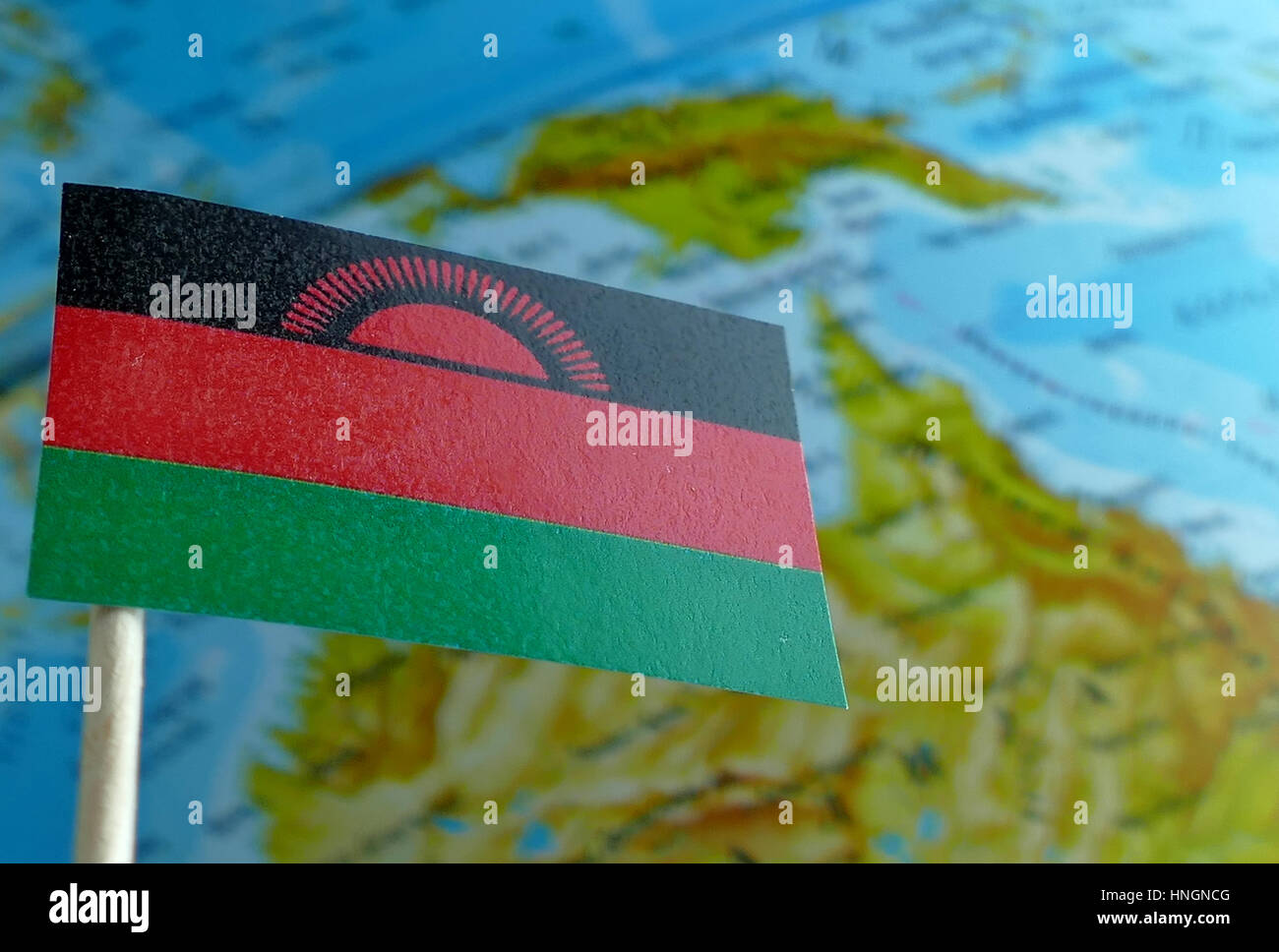 Malawi flag with a globe map as a background macro Stock Photo - Alamy