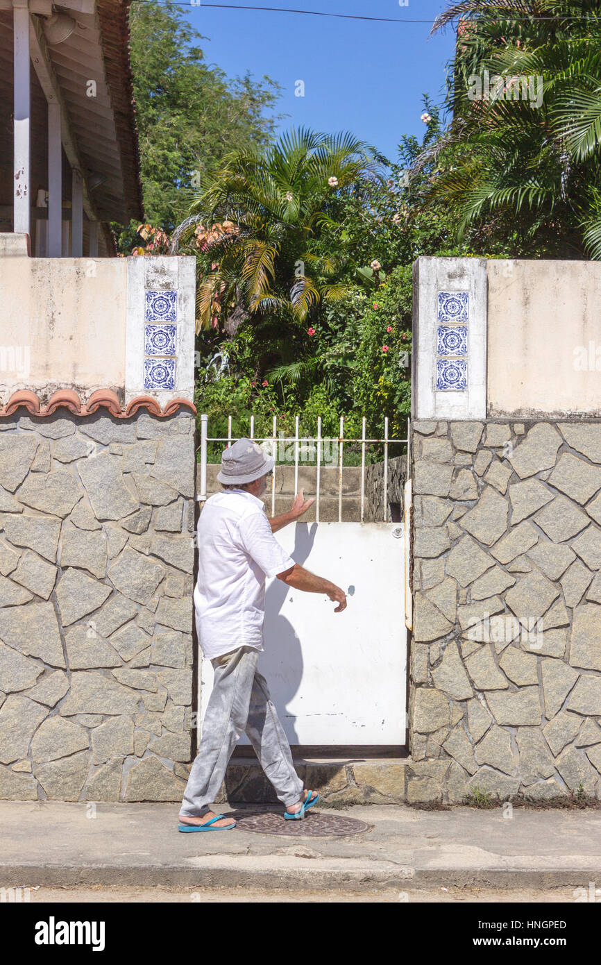 Brazil, State of Rio de Janeiro, Paqueta Island, Man entering gate of ...