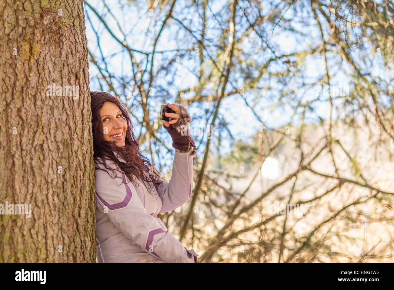 in the mountains a young retired woman is taking selfie and happy while ...