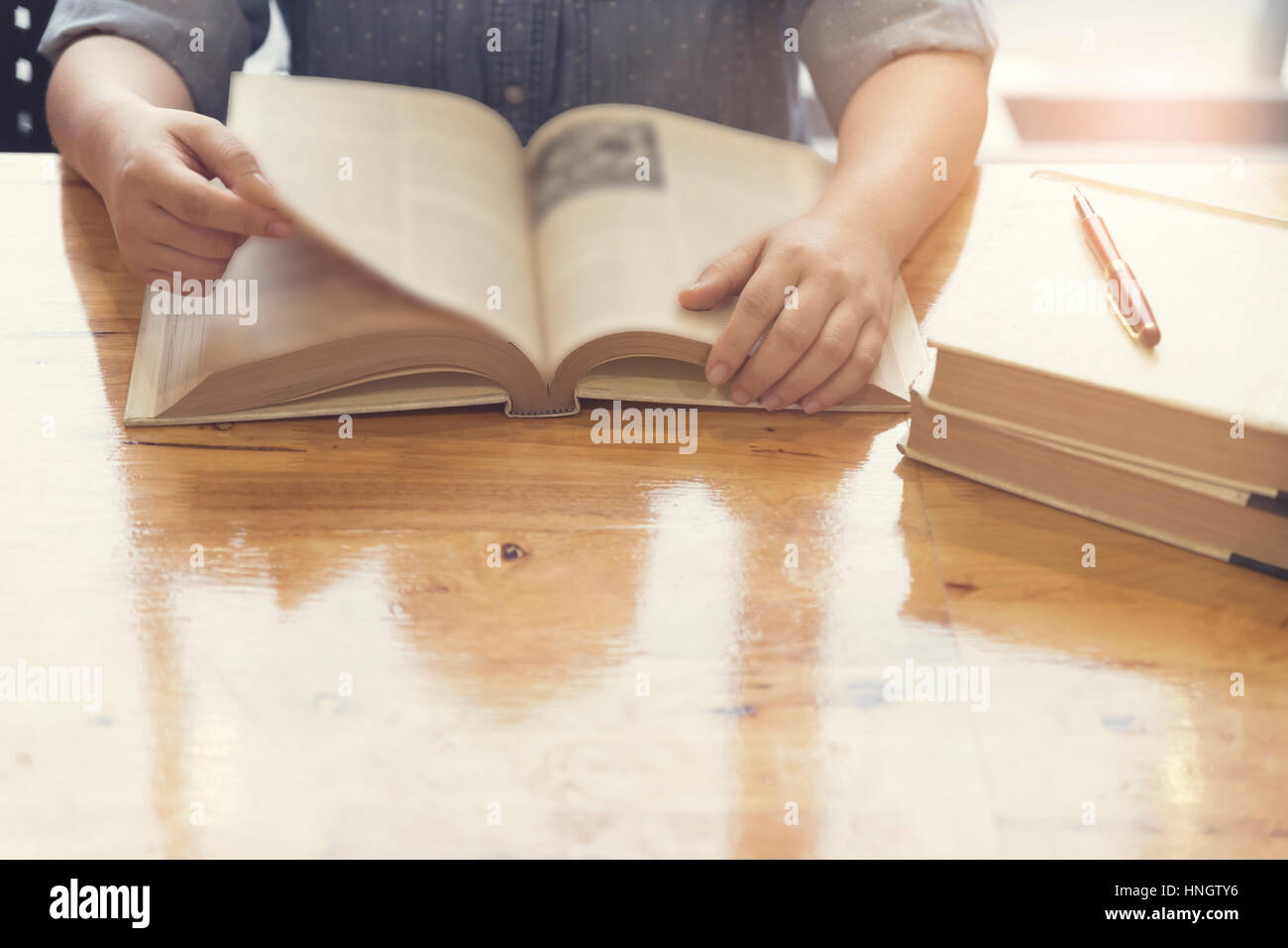 woman's hand reading book on wooden table, selective focus and vintage ...
