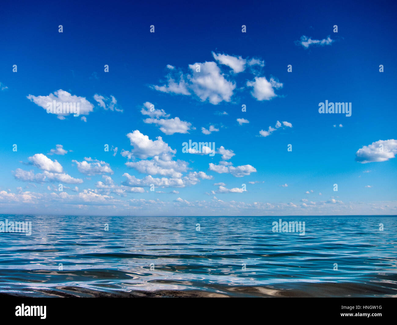 Sea with reflection from sky and clouds Stock Photo - Alamy