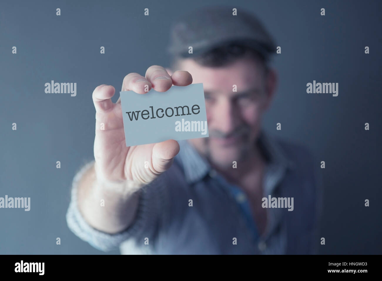 man holding up a card with the word Welcome Stock Photo - Alamy
