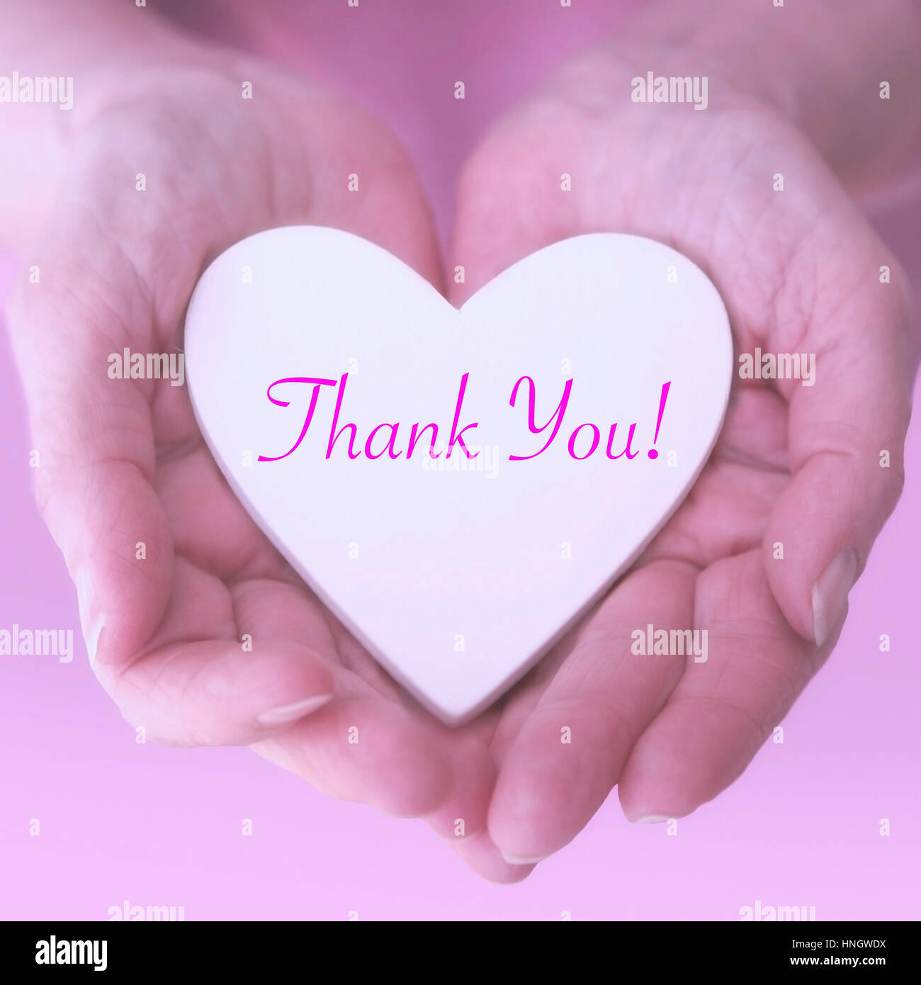 closeup of womans hands holding white heart with the words Thank You ...