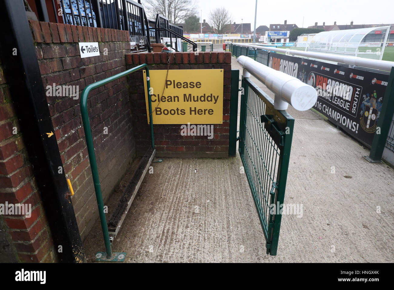 A sign reads "Please Clean Muddy Boots Here" next to the pitch at ...