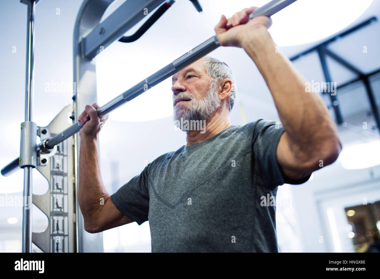 Senior man in gym doing pull-ups on horizontal bar Stock Photo - Alamy