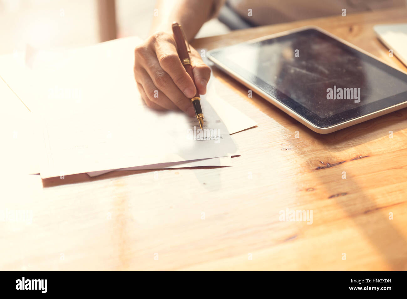 man's hand signing application form with tablet on wooden table ...