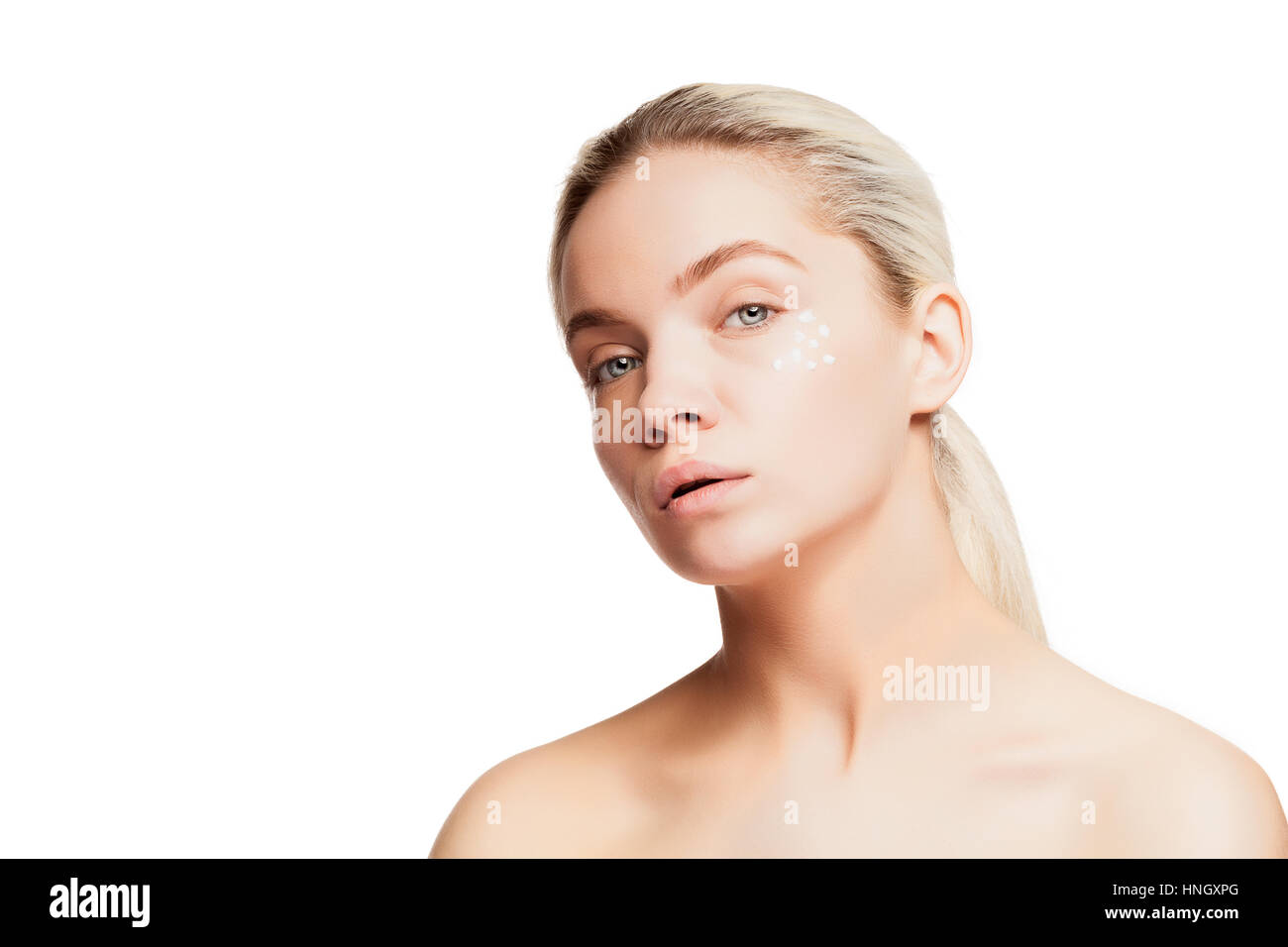 Beautiful woman with cream drops on face isolated on white background ...