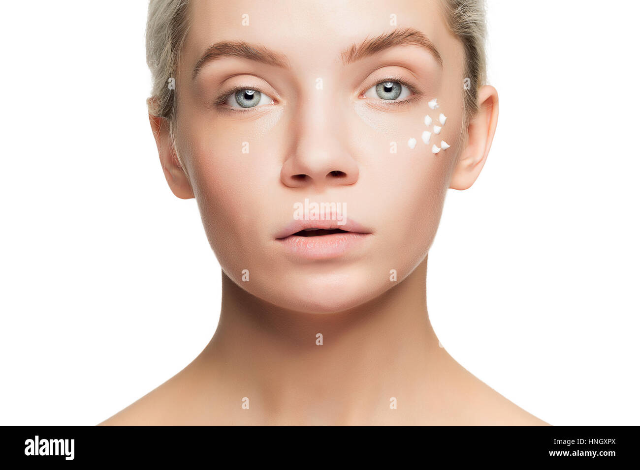 Woman with cream drops on face on white background in studio photo ...