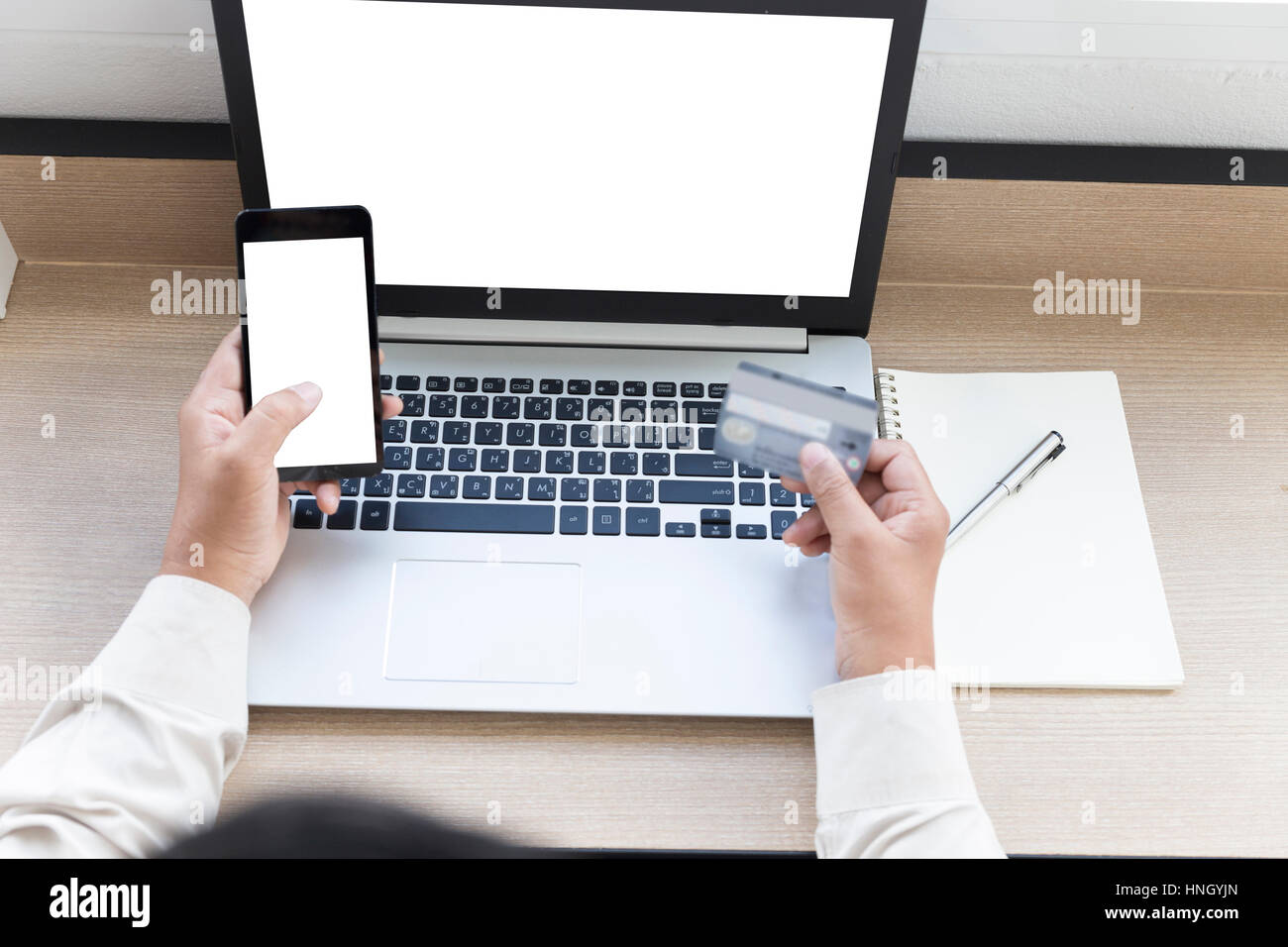 businessman's hand with mobile phone, laptop computer and credit card ...