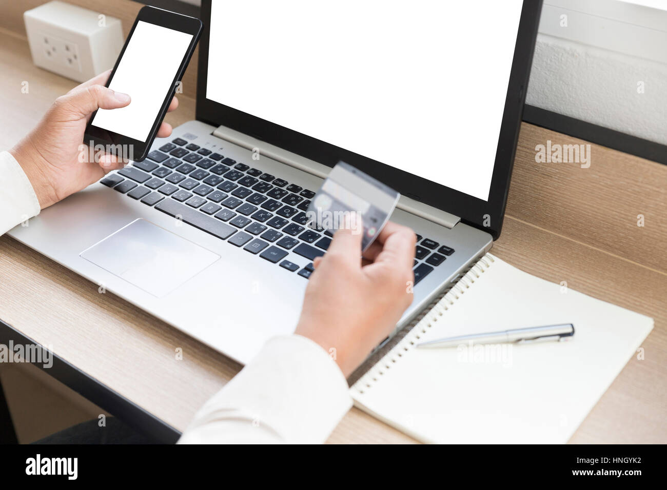 businessman's hand with mobile phone, laptop computer and credit card ...