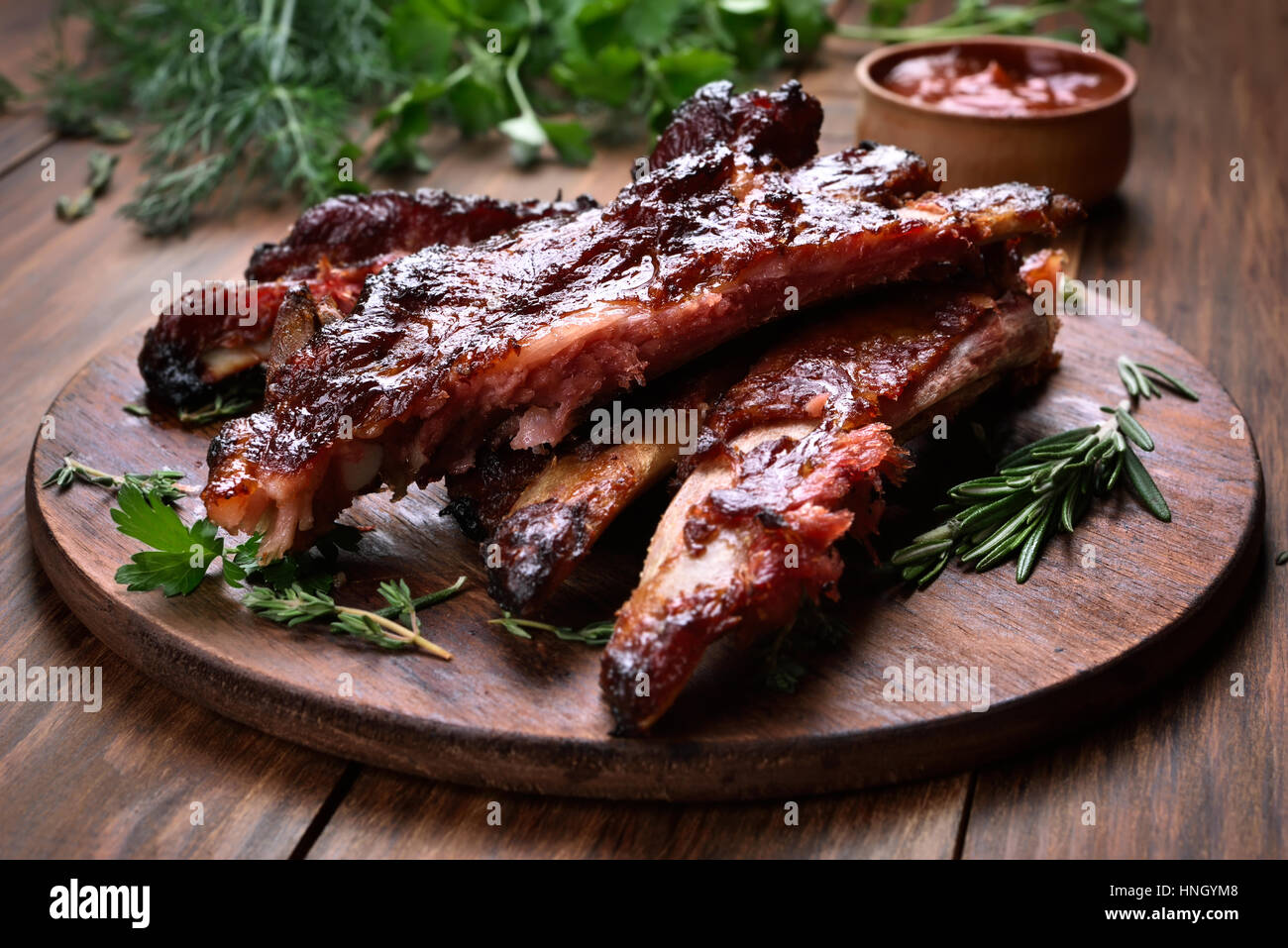 Grilled sliced barbecue pork ribs on wooden board, shallow depth of ...