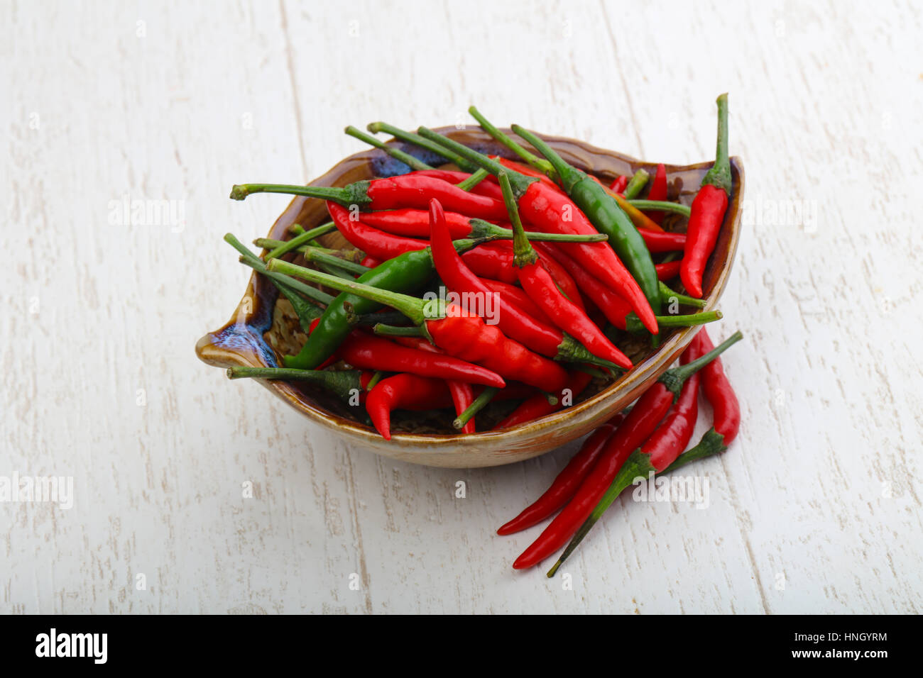 Hot chili pepper heap on the wood background Stock Photo - Alamy