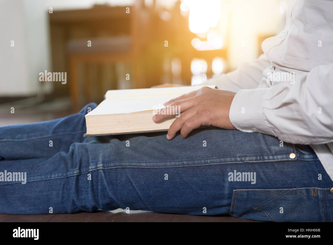 man sitting and reading book on floor in aisle in library Stock Photo ...
