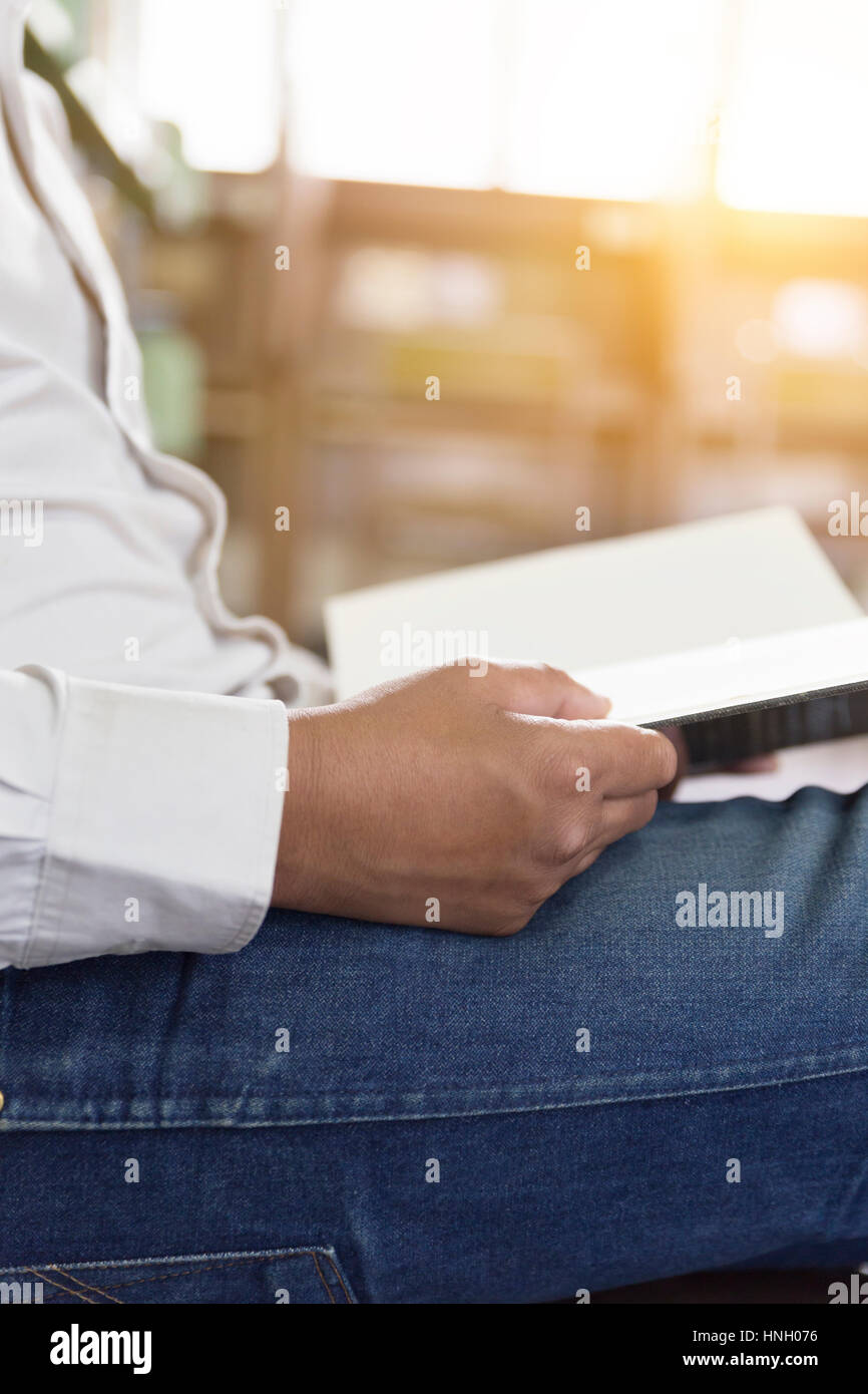 man sitting and reading book on floor in aisle in library Stock Photo ...