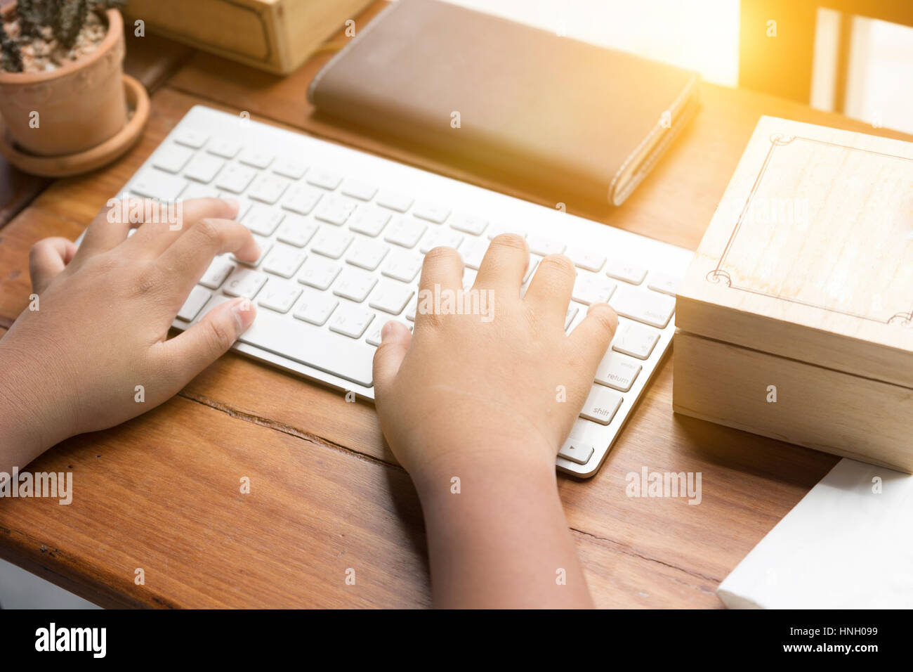kid's hand on computer keyboard with notebook and wooden box Stock ...