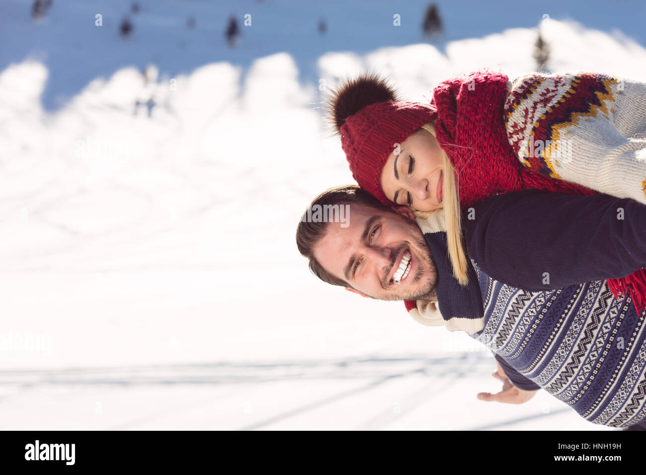 Man holding girlfriend on his back at the top of mountain Stock Photo ...
