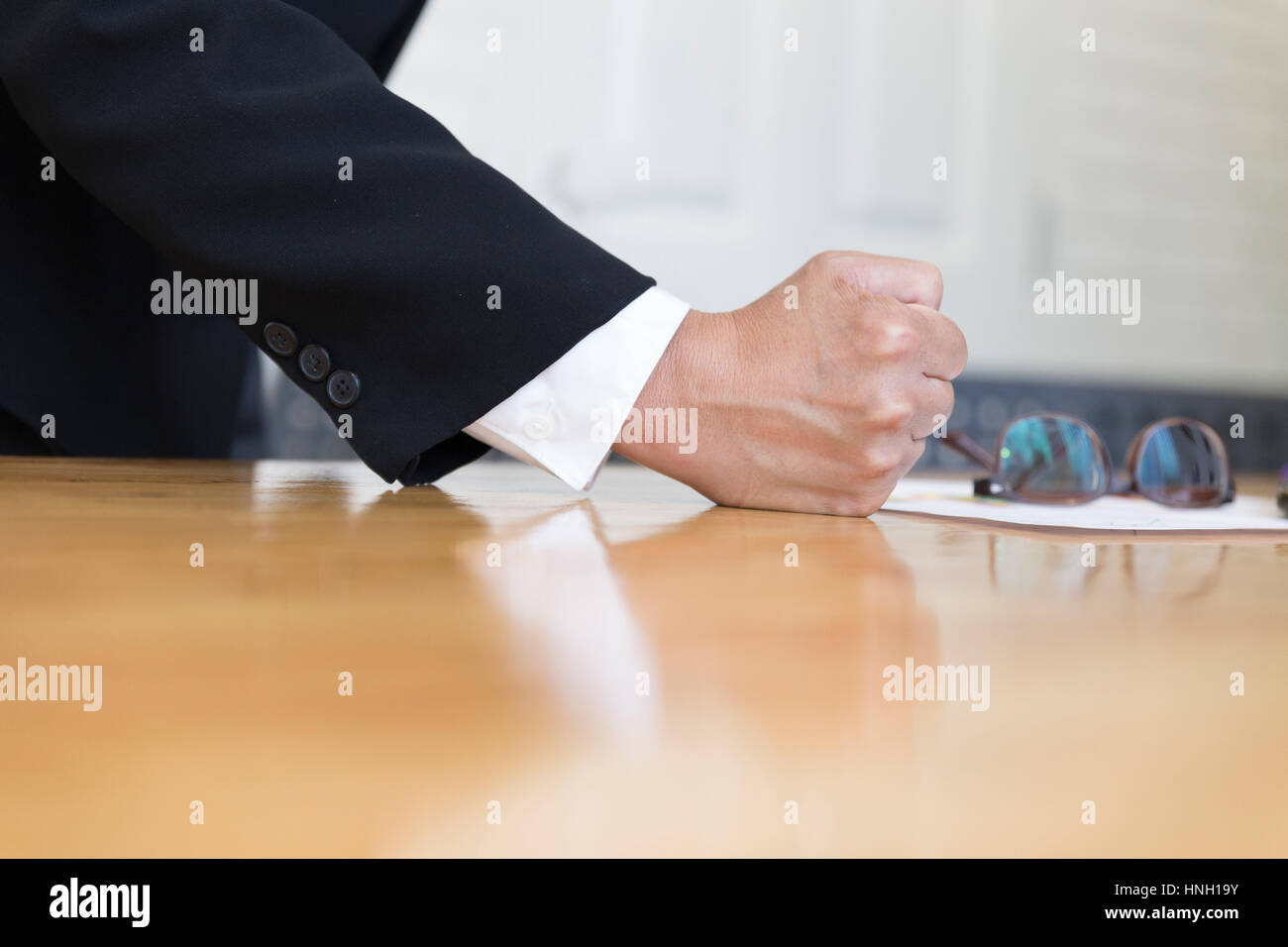 clenched fist of businessman on office desk - angry and furious ...