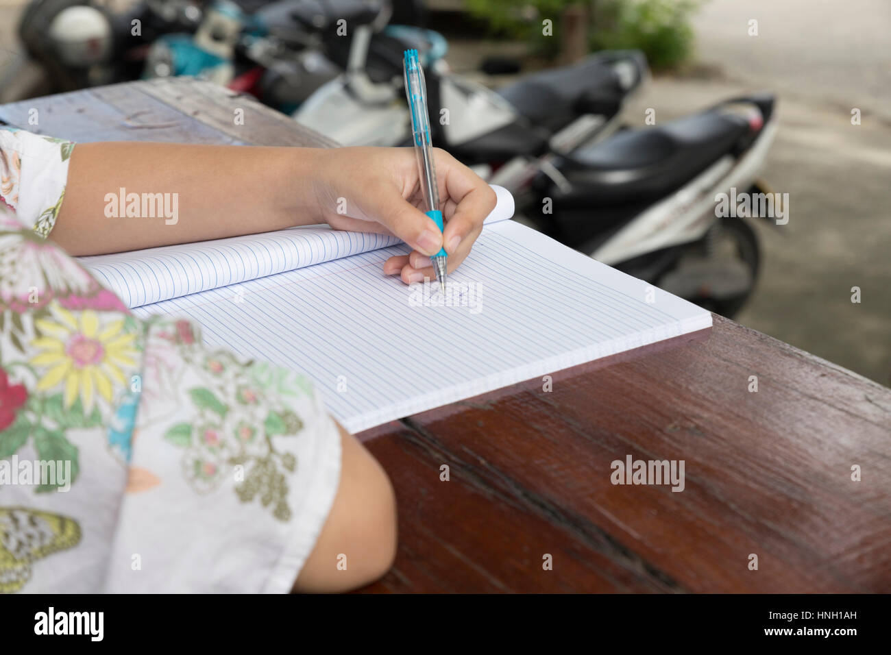 girl's hand holding pen writing on notebook Stock Photo - Alamy